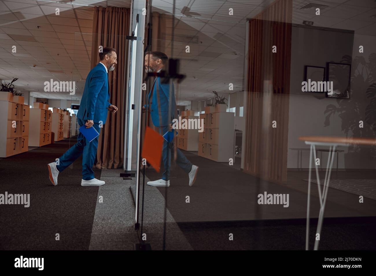 Positive man in a suit following in the negotiation room Stock Photo ...