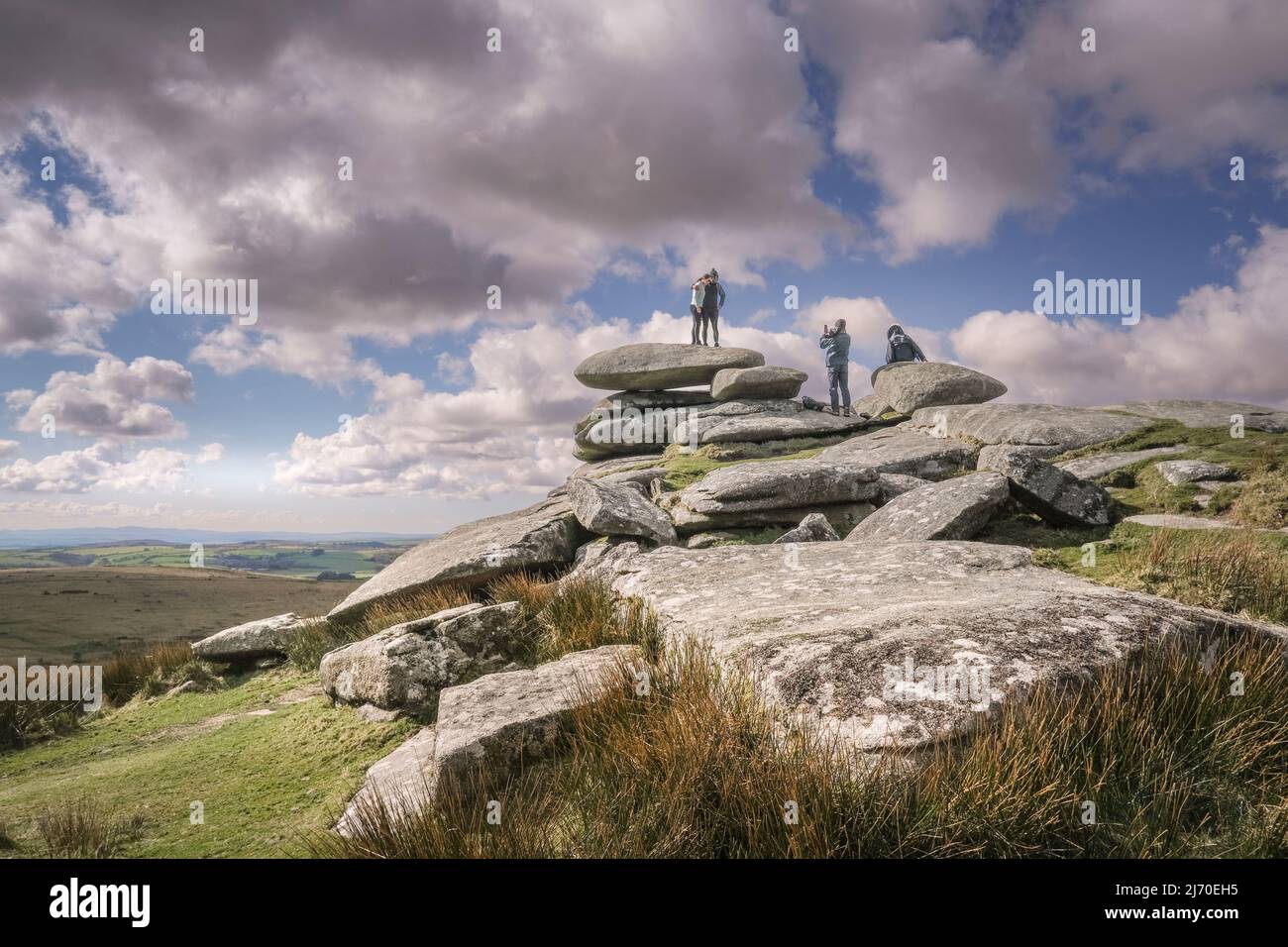 Walkers posing on a granite rock stack formed by glacial action and ...