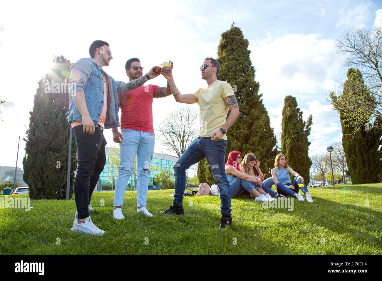three friends toasting at a party and a group of girls having fun while ...