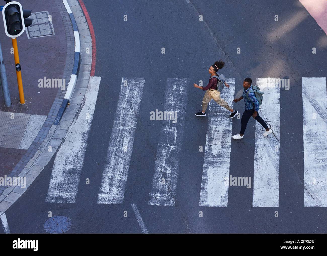 Two young pedestrians cross the road on a crosswalk in the city Stock ...