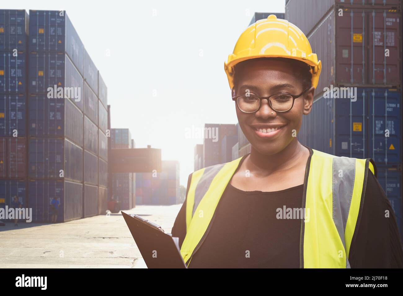 Portrait Black African woman engineer staff working in port cargo container yard for shipping ...