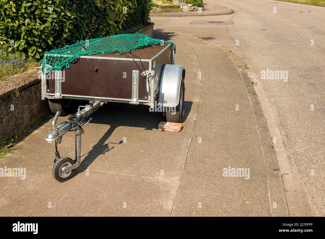 Trailer with earth on the sidewalk Stock Photo - Alamy