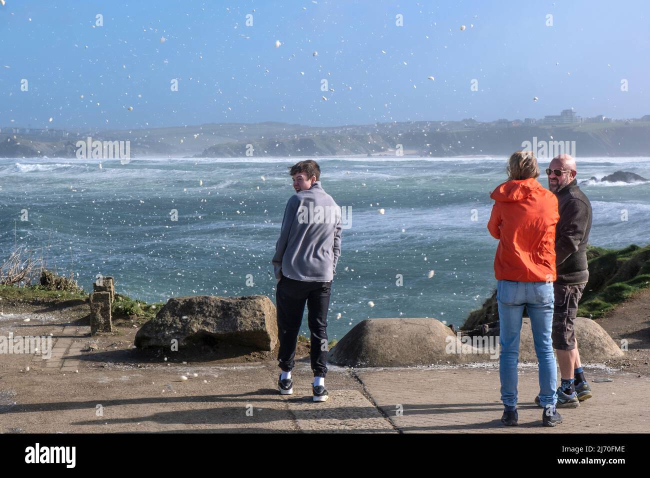 Sea foam blown around people in high winds brought by Storm Eunice in ...
