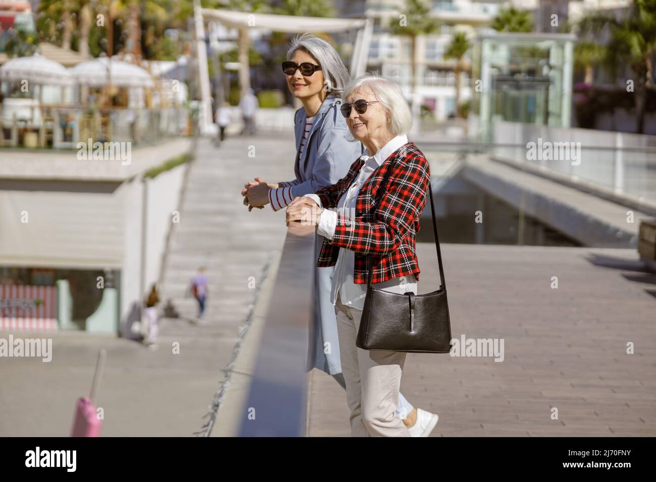 Enthusiastic women spending time together in city Stock Photo - Alamy