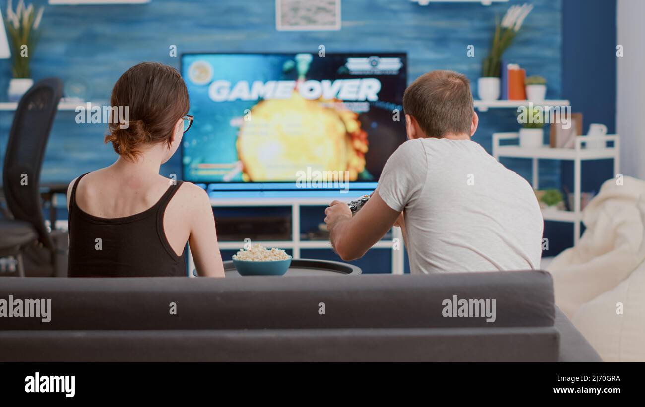 Couple arguing over man losing online game on console in front of big ...