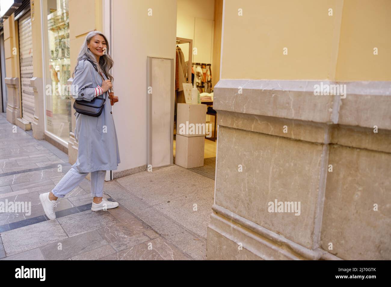 Busy mature woman taking stroll through city Stock Photo - Alamy