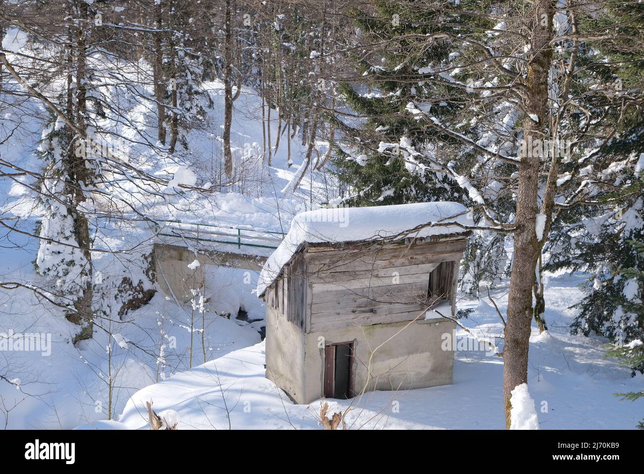 Winter concept idea. Huge amount of snow around small shed and cottage ...