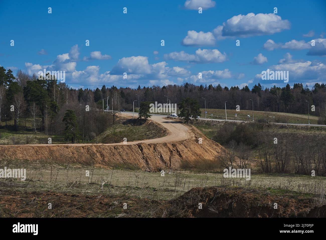 Sandy road leading to the quarry, through the forest. Sunny spring ...