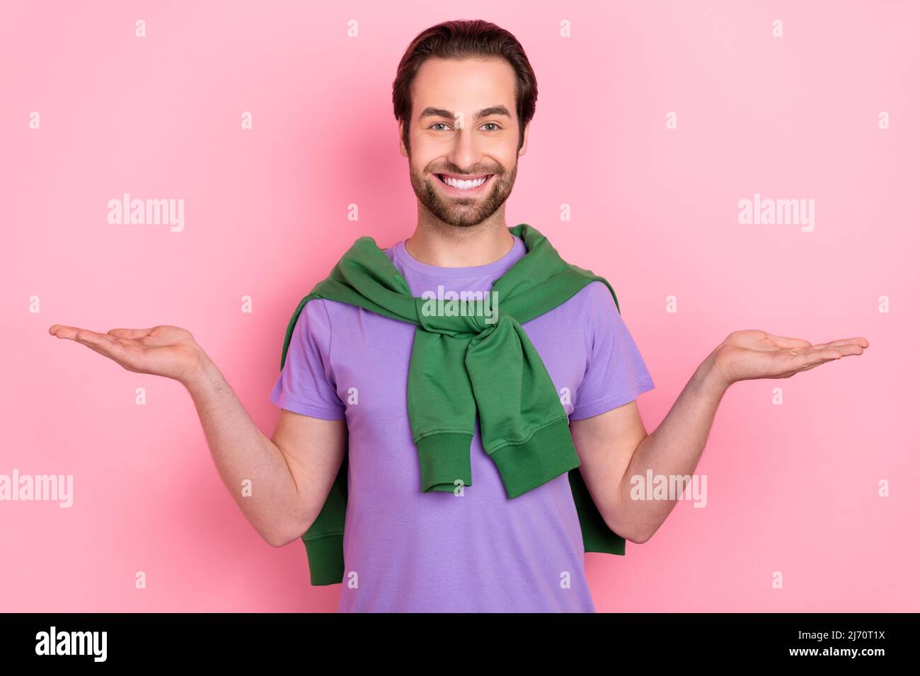 Photo of young cheerful man compare two products objects can't decide ...