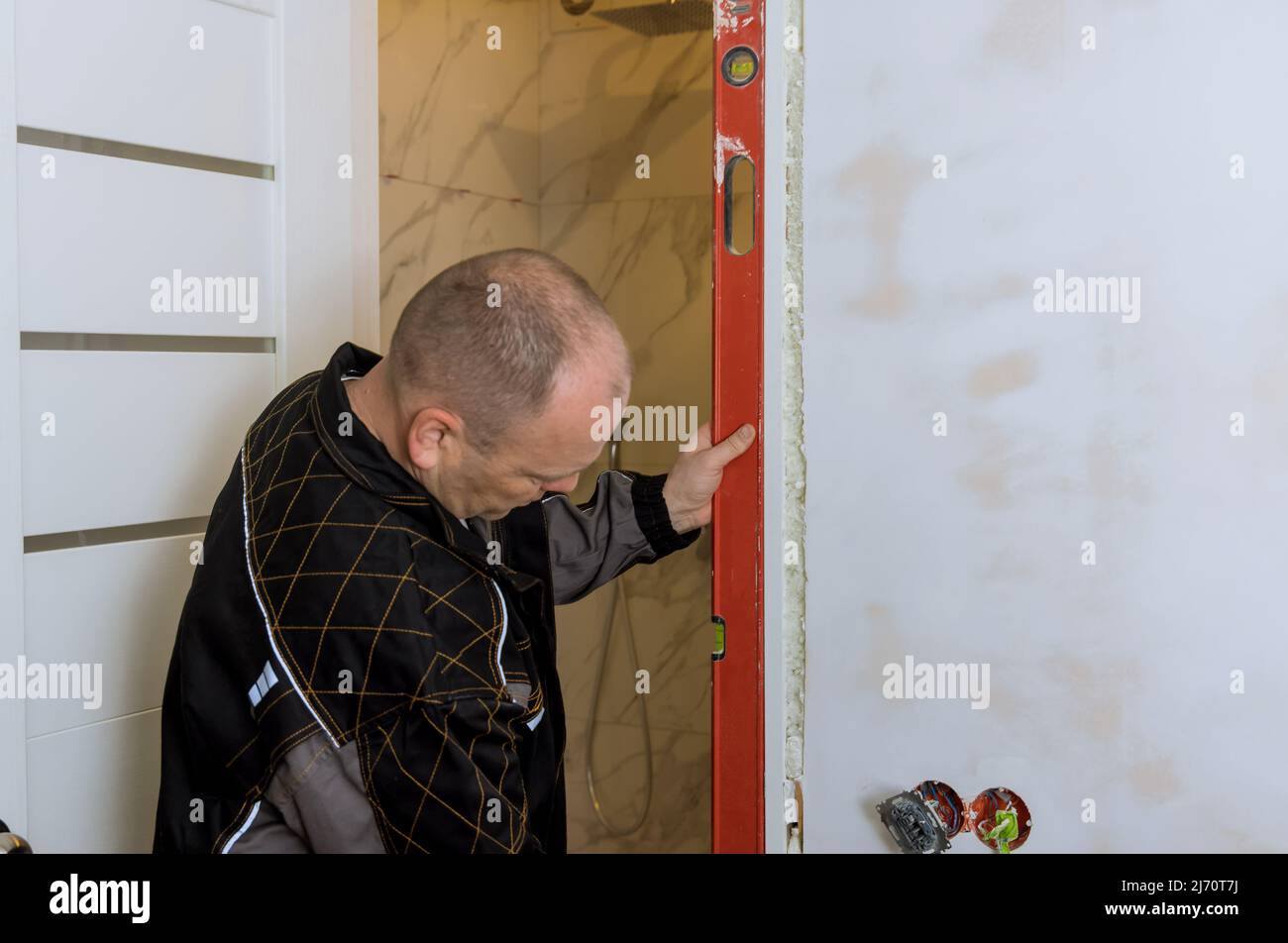 Interior wood door installation working with level Stock Photo - Alamy