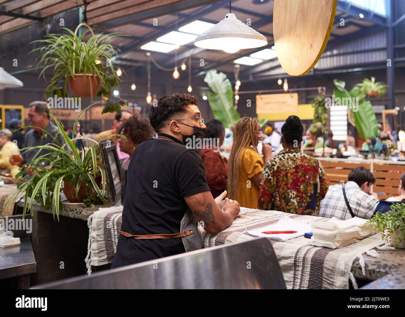 A food stall owner waits for customers at his taco stall at a busy ...