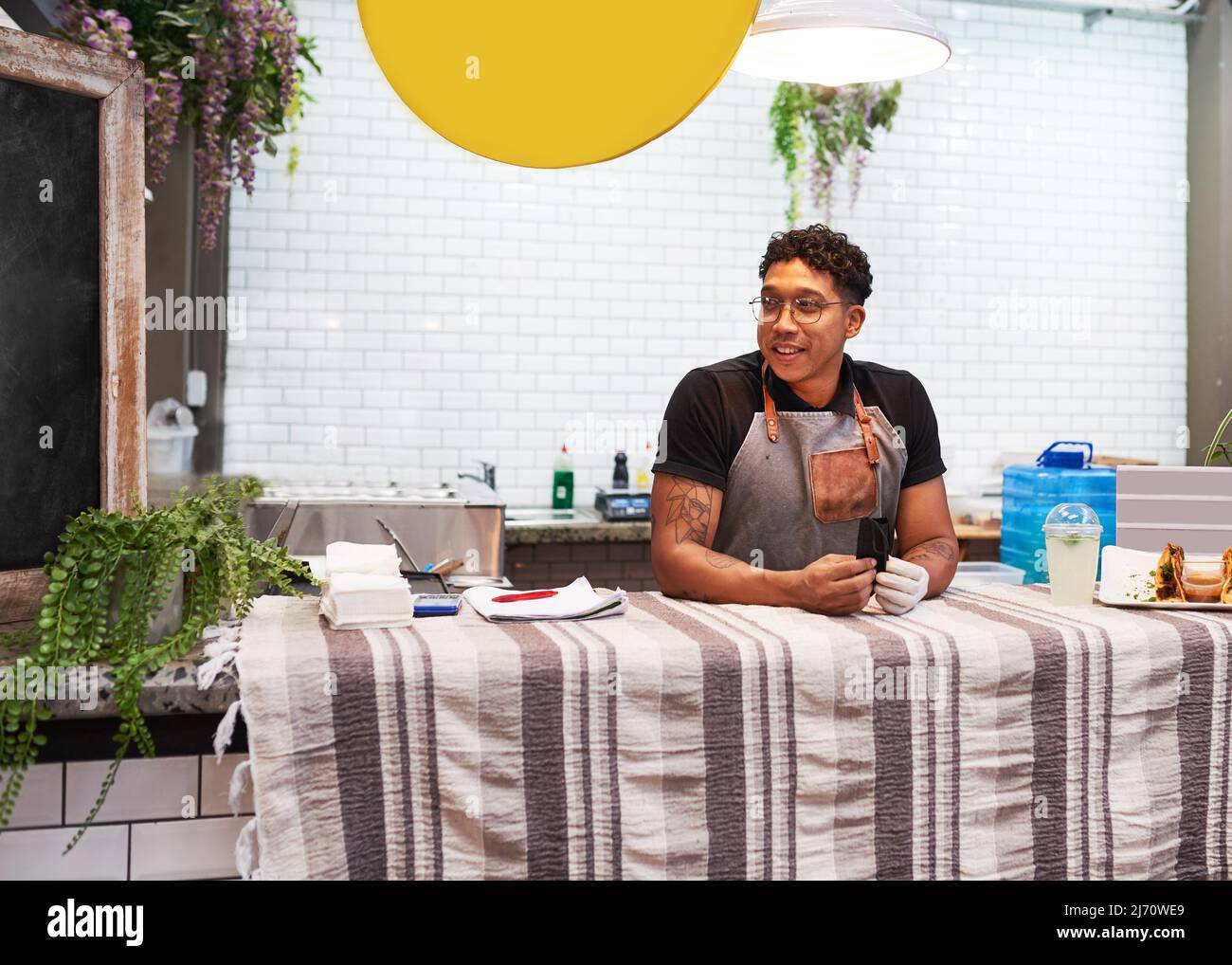 A small business owner waits behind food stall for customers Stock ...