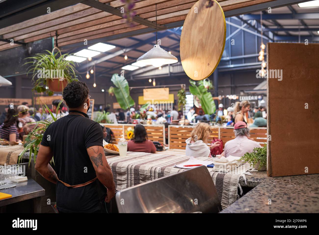 A food stall owner waits for customers at his taco stall at a busy ...