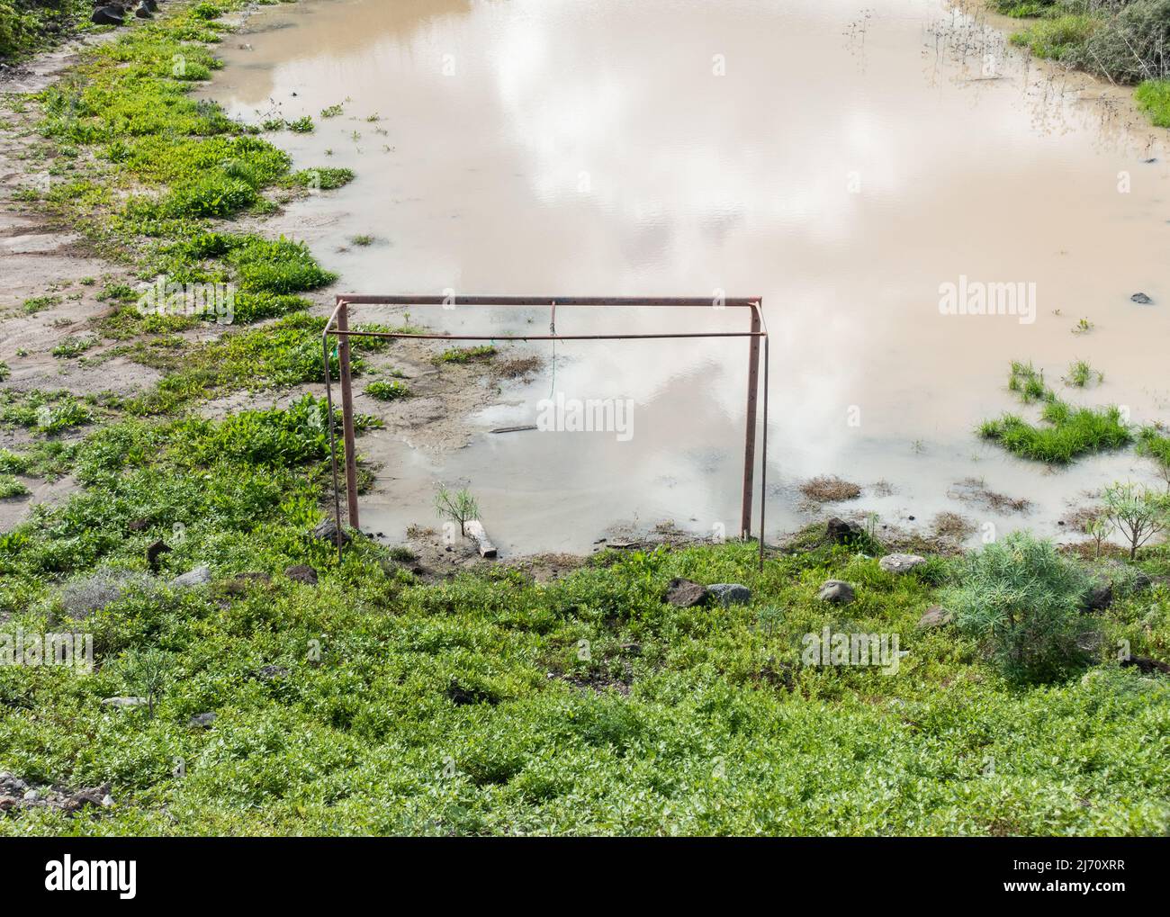 Goal posts on flooded, waterlogged, overgrown football pitch Stock ...