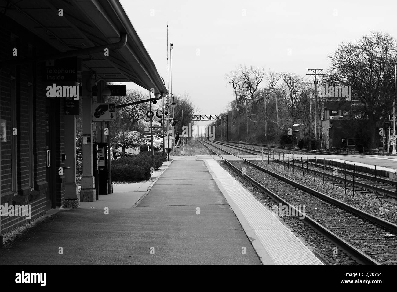 Small town train station platform with typical train tracks in black ...