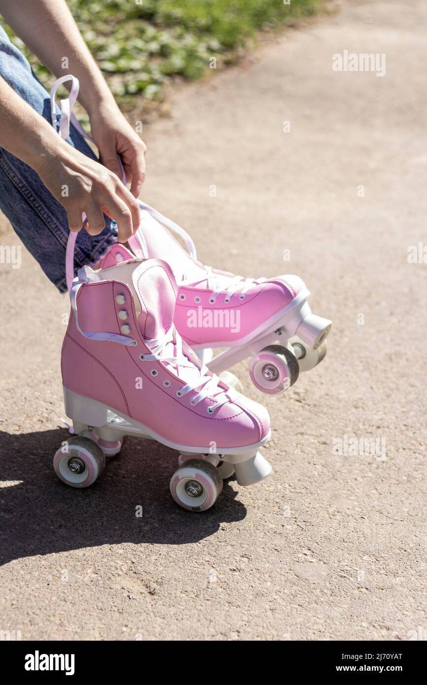 legs of a woman tying pink roller skates Stock Photo - Alamy