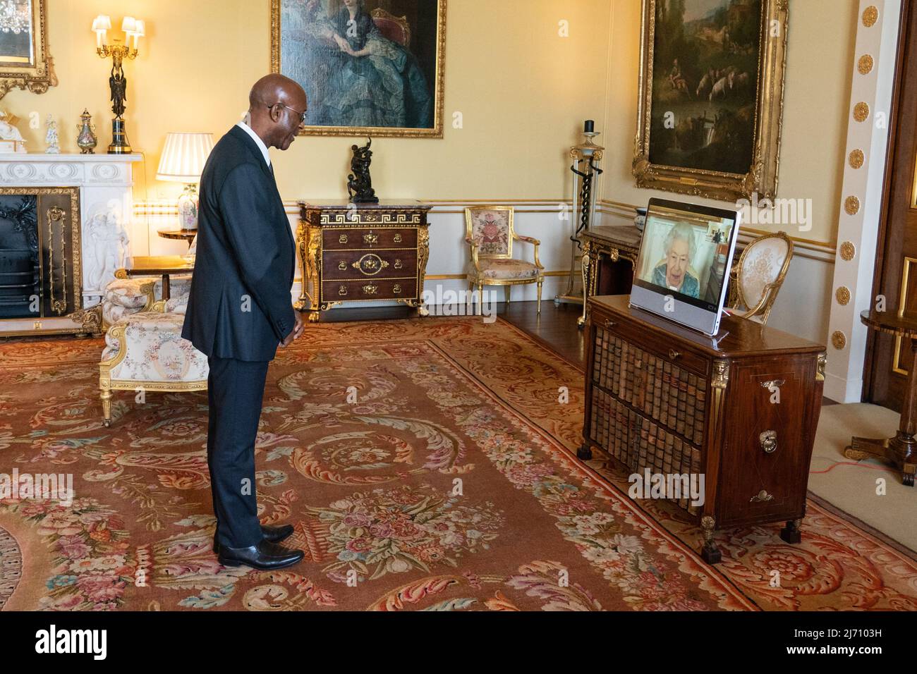 Queen Elizabeth II, in residence at Windsor Castle, appears on a screen ...