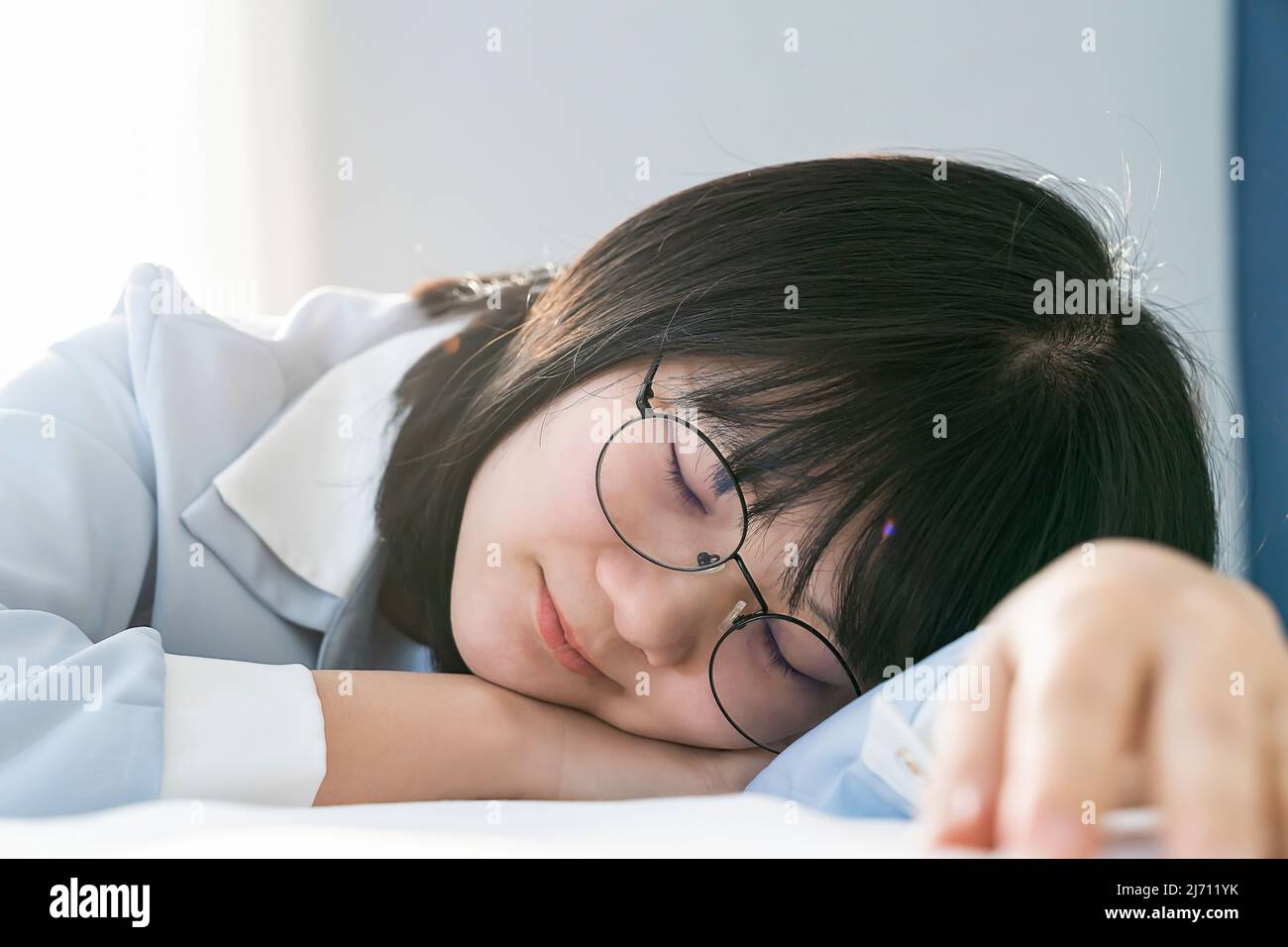 Asian Glassese cute woman takes a nap and relax on bed in the afternoon ...