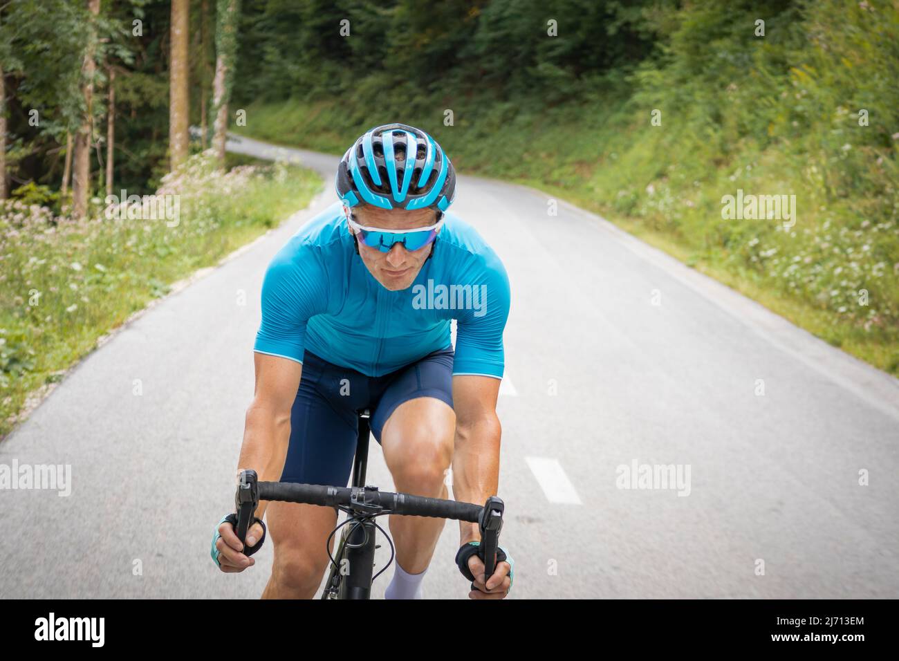 Caucasian male cyclist with professional racing sports gear riding on ...