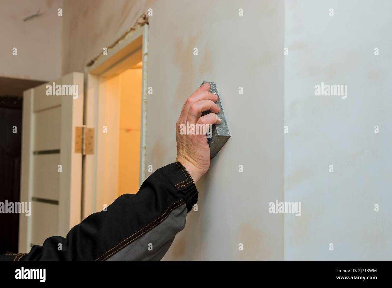 Contractor using sand trowel sanding the drywall Stock Photo - Alamy
