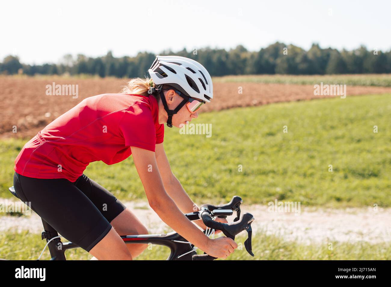 Young female professional bicyclist during road cycling sprint ...