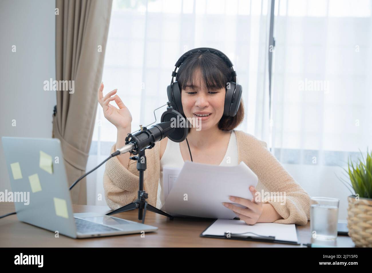 Woman speaking expressively with hand gestures into a microphone at ...