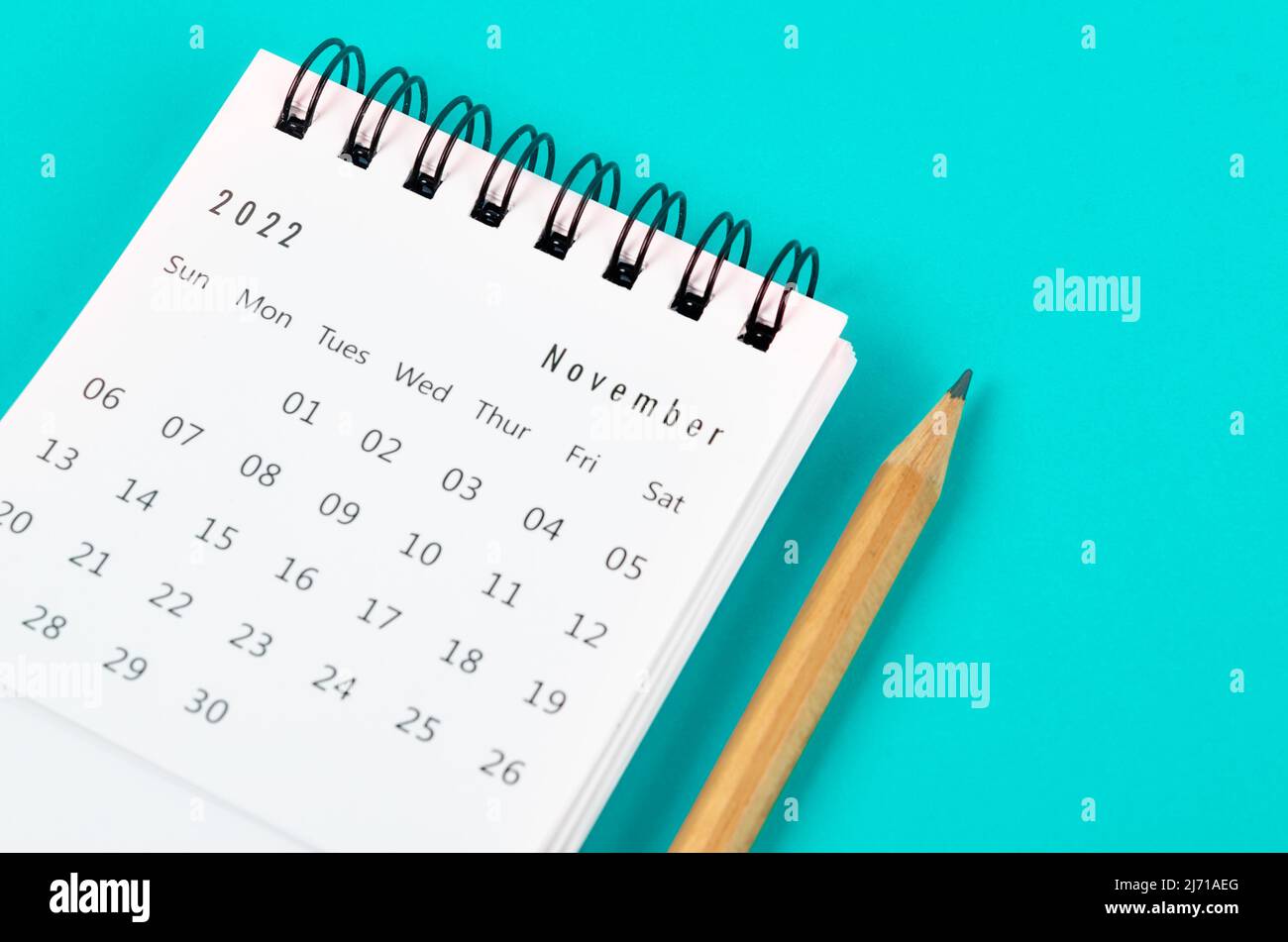 The November 2022 desk calendar with wooden pencil on light blue ...