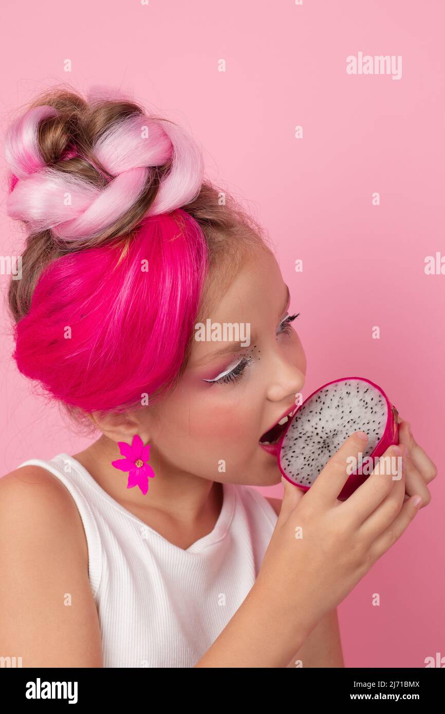 Close-up portrait of pretty girl with pink hairstyle with dragon fruit ...
