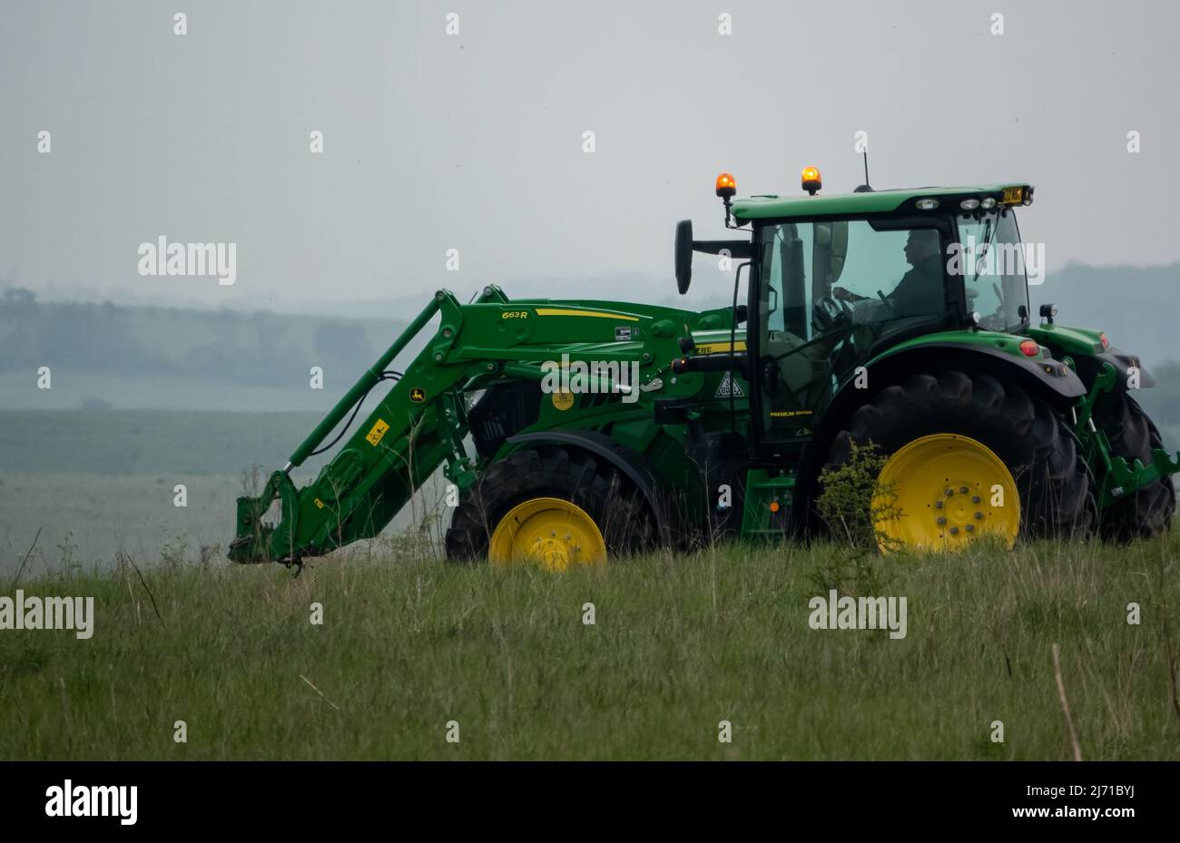 John Deere 6215R farm tractor in motion with front lifter Stock Photo - Alamy