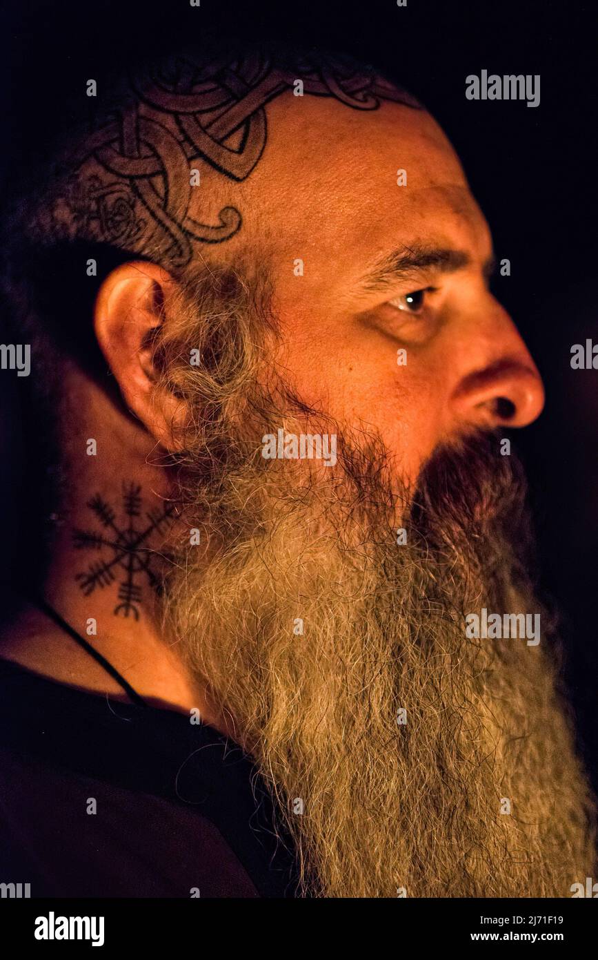 A member of the pagan community shows off his beard and tattoos. The ...