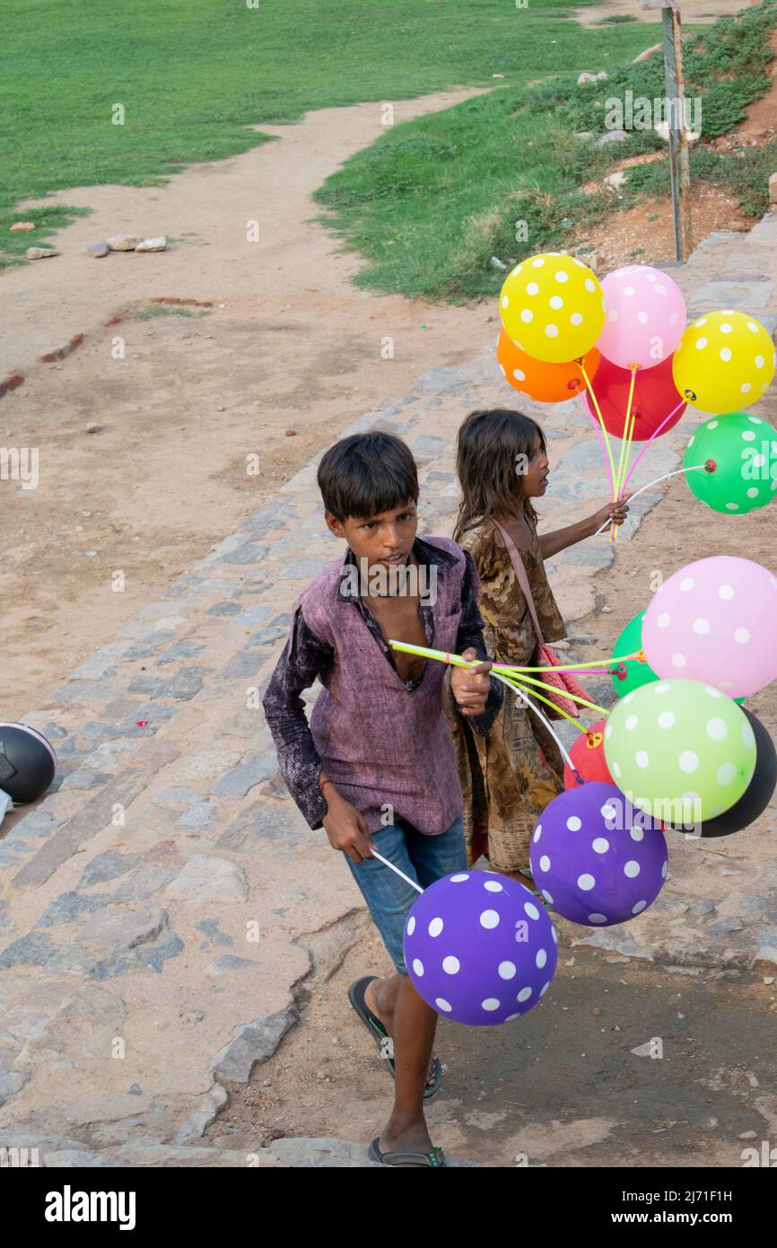A dark Indian girl is trying to sell balloons, Concept - Child labor ...