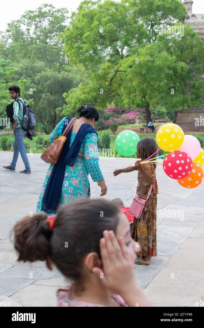 A dark Indian girl is trying to sell balloons, Concept - Child labor ...