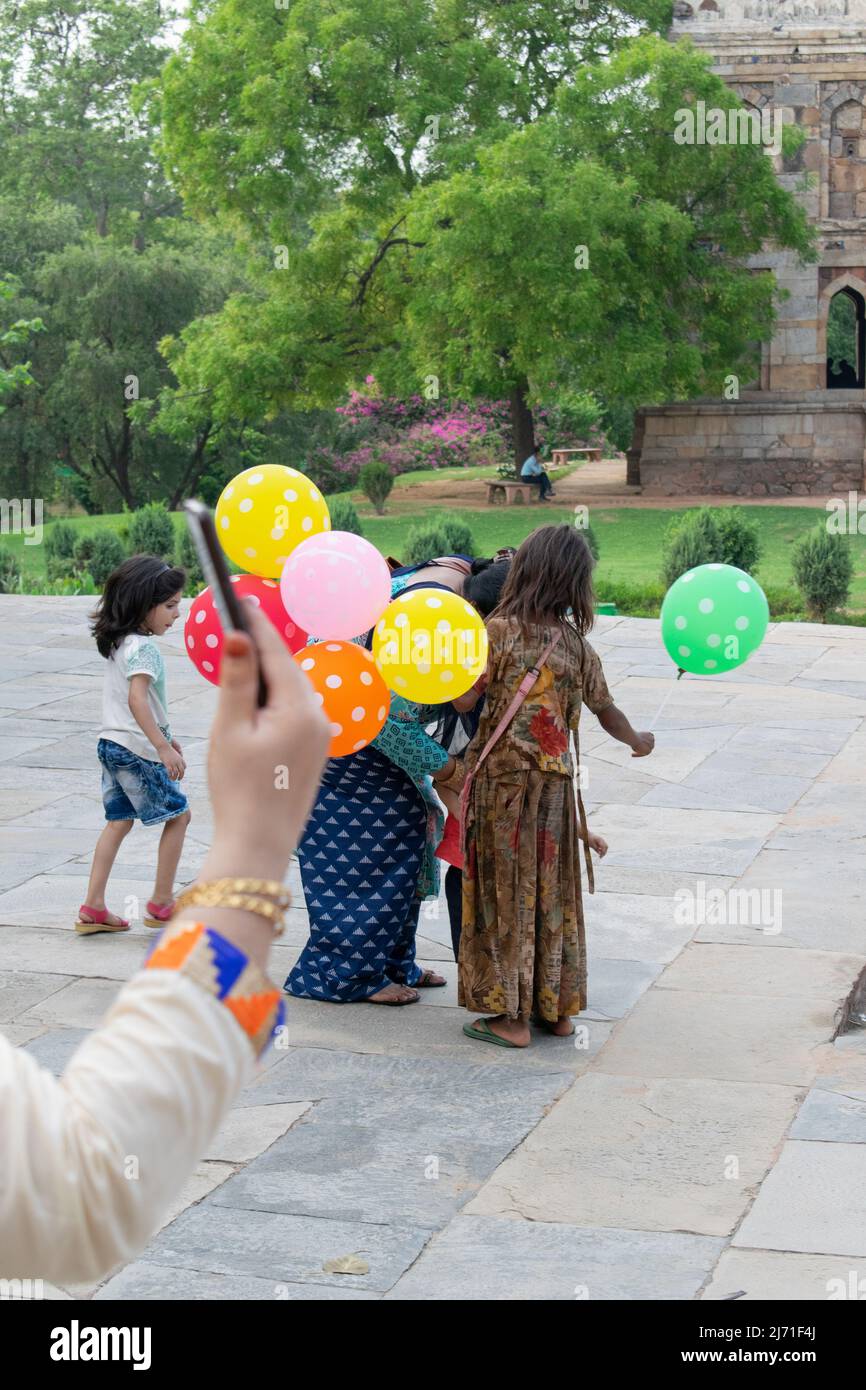 A dark Indian girl is trying to sell balloons, Concept - Child labor ...