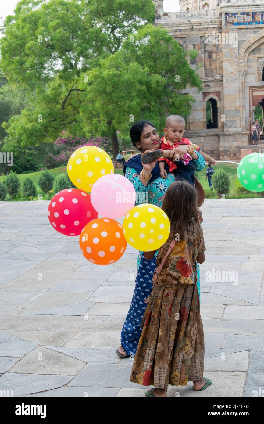 A dark Indian girl is trying to sell balloons, Concept - Child labor ...