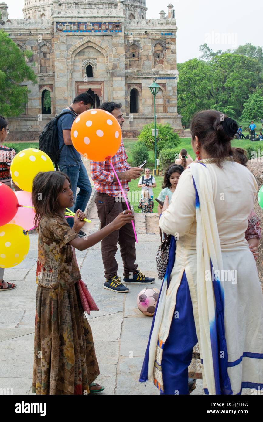 A dark Indian girl is trying to sell balloons, Concept - Child labor ...