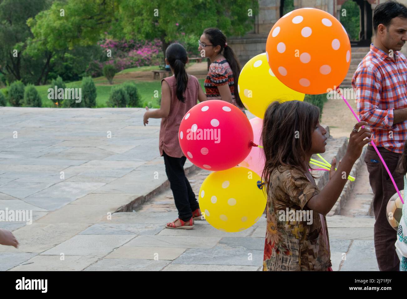 A dark Indian girl is trying to sell balloons, Concept - Child labor ...