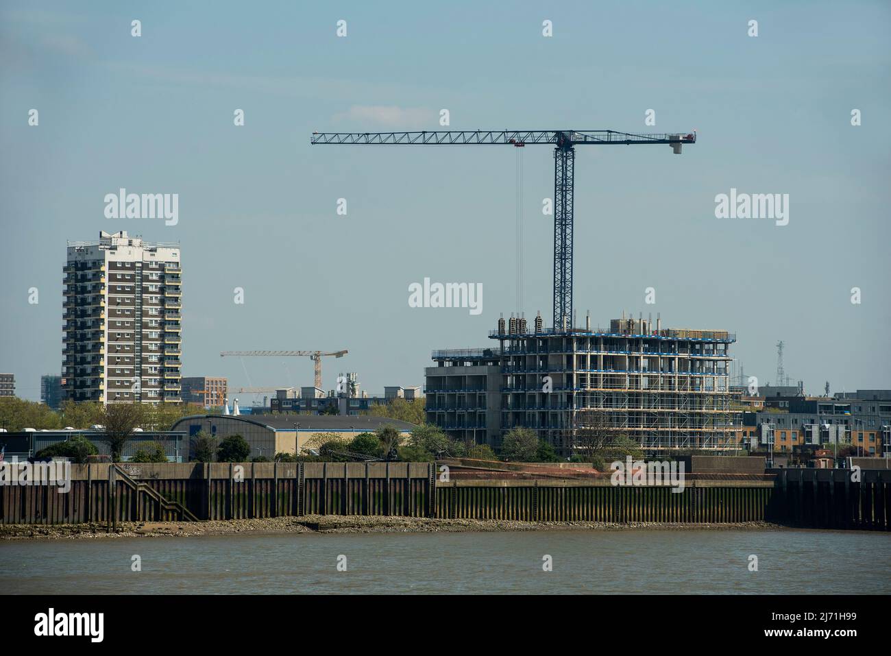 Tower cranes loom over modern city apartment blocks under construction ...
