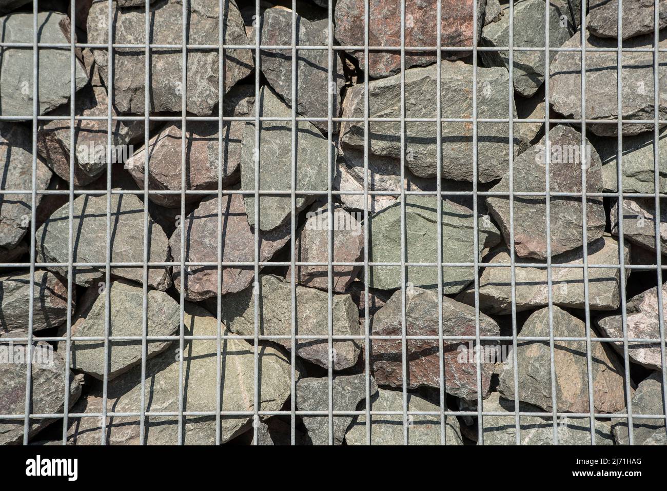 Close up of a gabion, rocks packed into a wire mesh form typically to ...