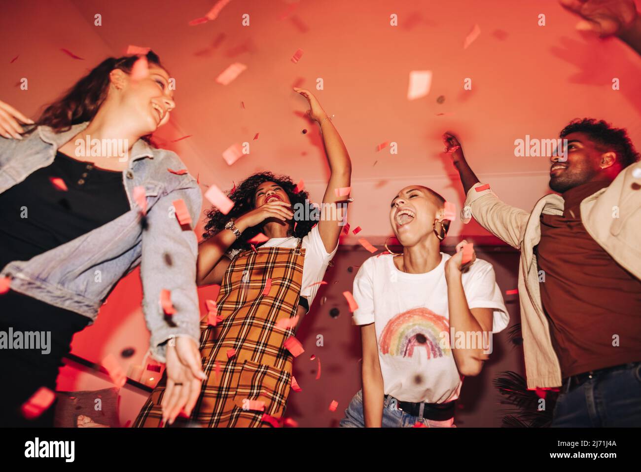 partying hard and having fun. Group of happy friends dancing to their ...