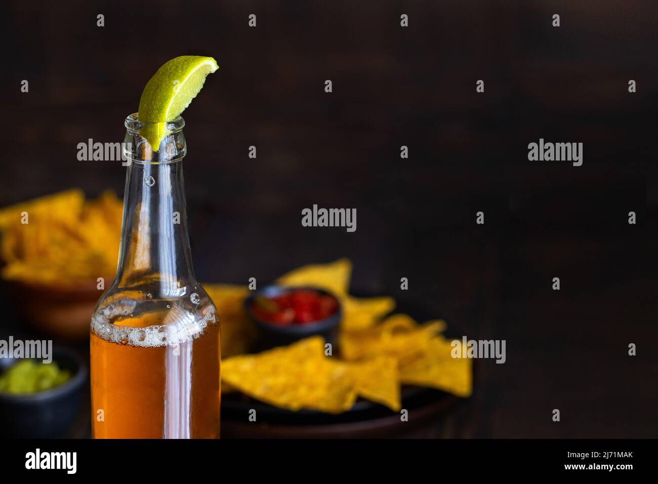 Mexican cerveza or bear with lime juice and Mexican snack nachos with ...