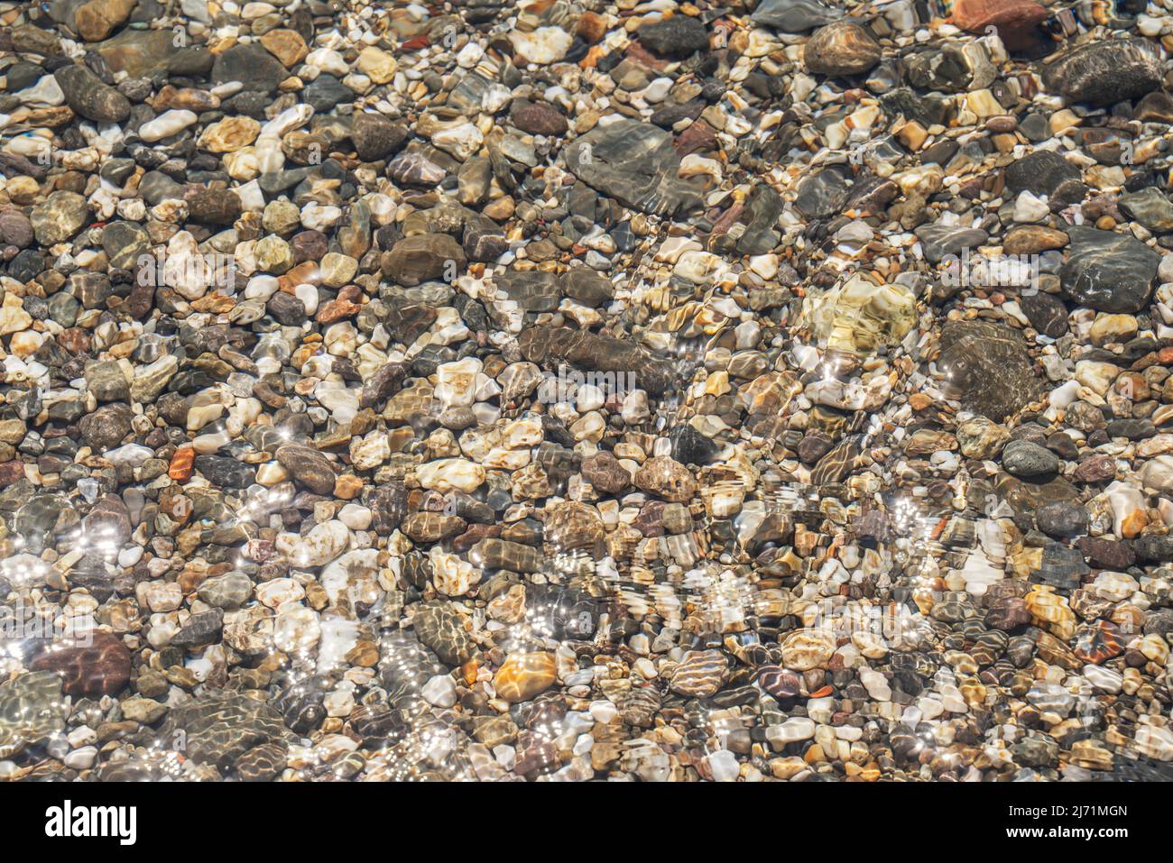 Pebbles under water. Sea stones in the sea water. The view from the top ...