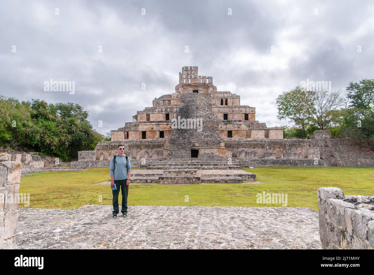 Tourist man posing in front of the mayan ruins of Edzna pyramid (Temple ...
