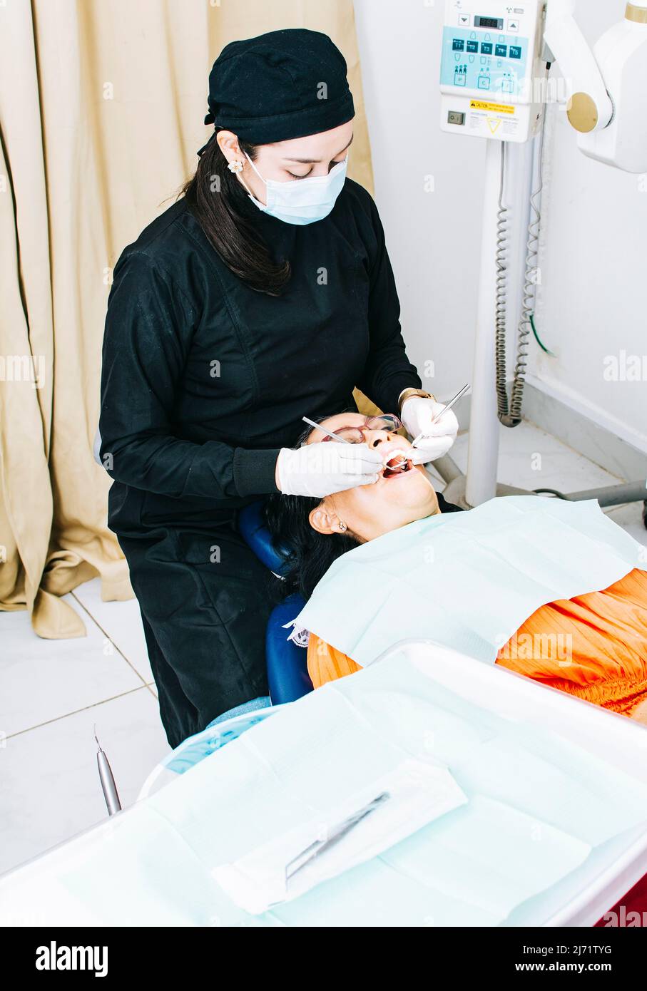 Dentist with patient lying down, Dentist examining mouth to patient ...