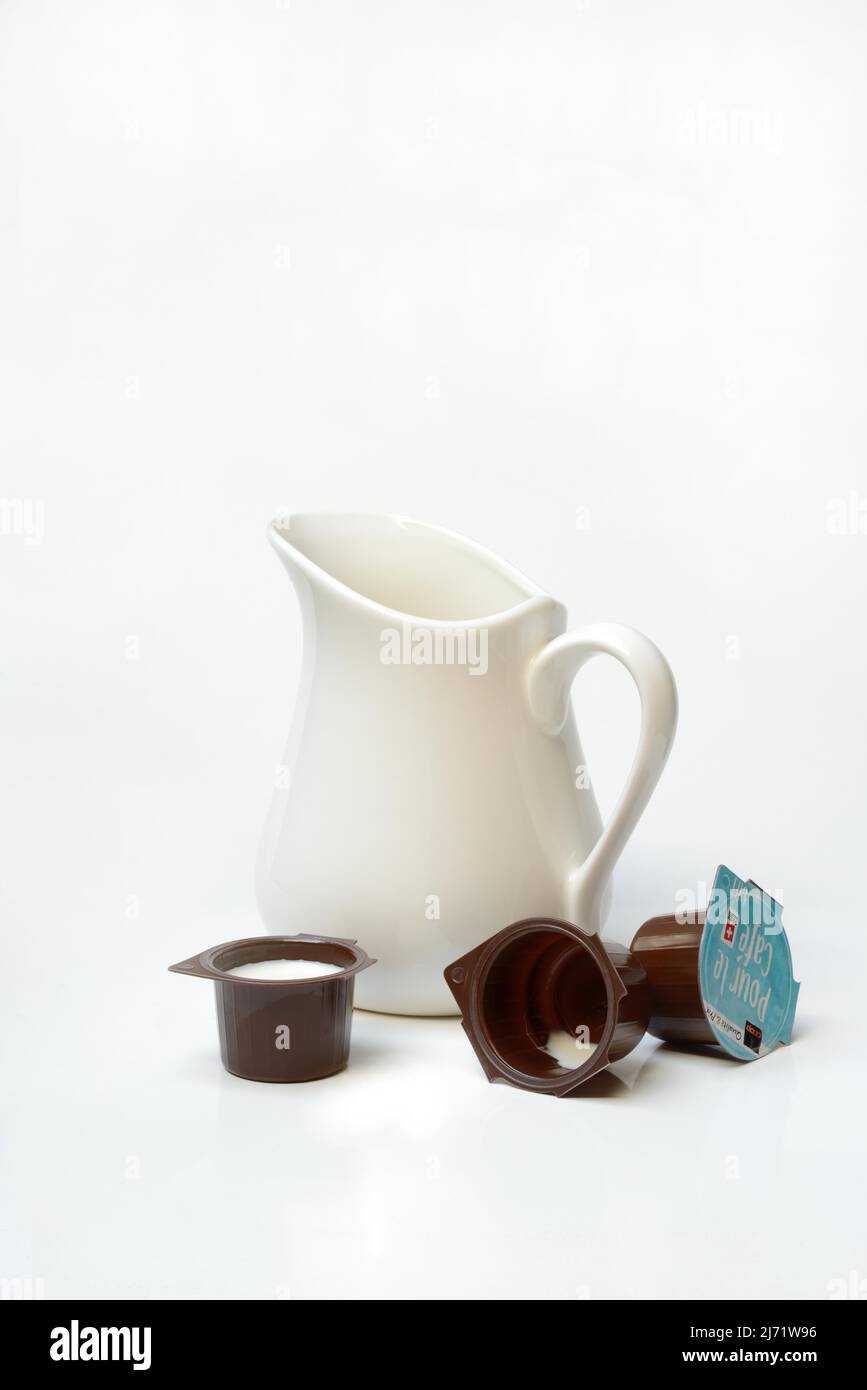 A milk can and milk in portion pack, white background Stock Photo - Alamy
