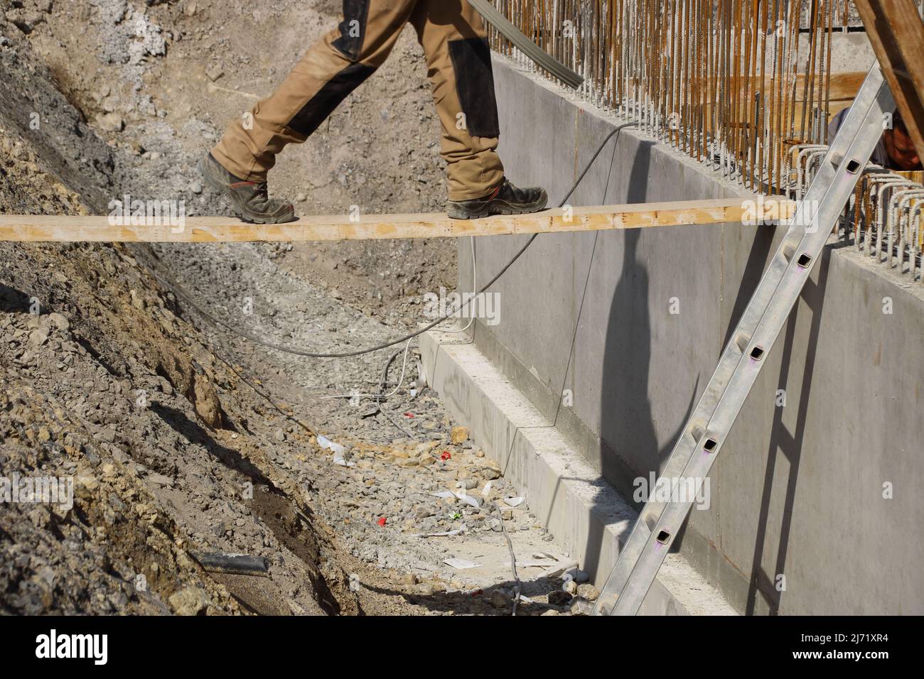 Worker goes on a narrow board over a pit Stock Photo - Alamy