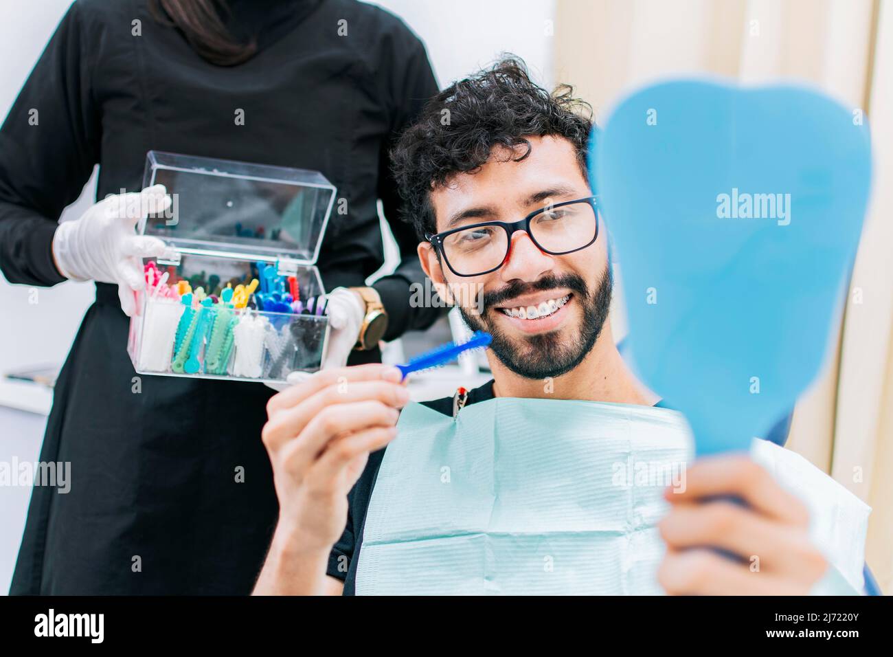 Dentist with patient choosing metal braces, Patient with dentist ...