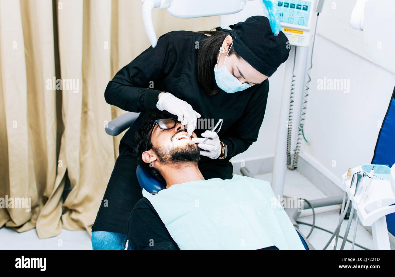 Dentist performing dental checkup, dentist checking braces to patient ...