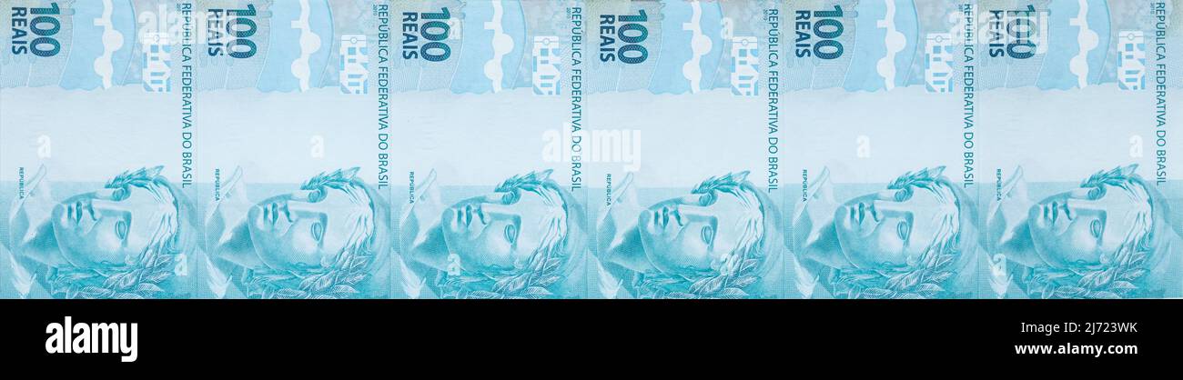 Brazilian banknotes of 100 Reais arranged neatly next to each other ...