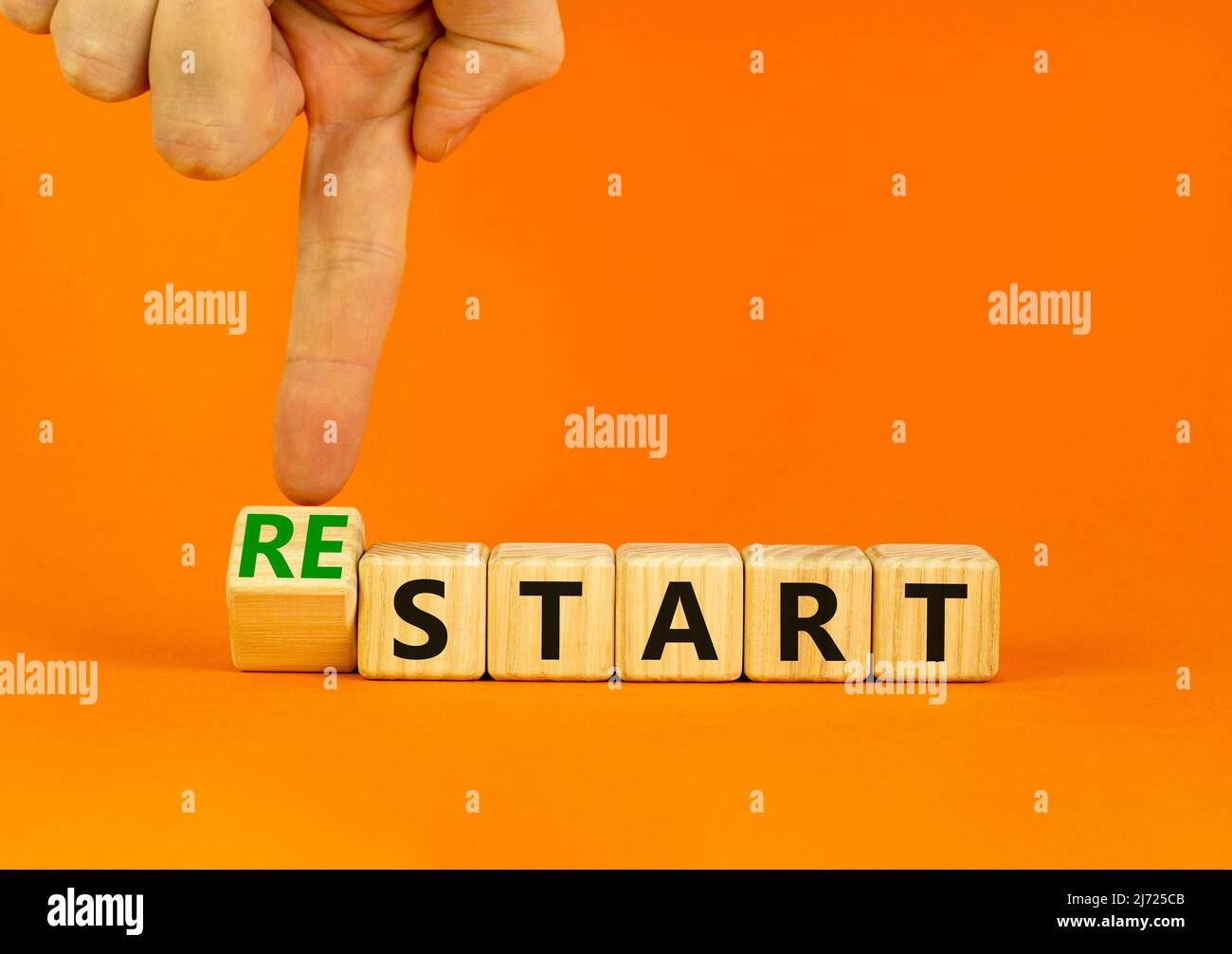 Start or restart symbol. Businessman turns wooden cubes and changes the ...