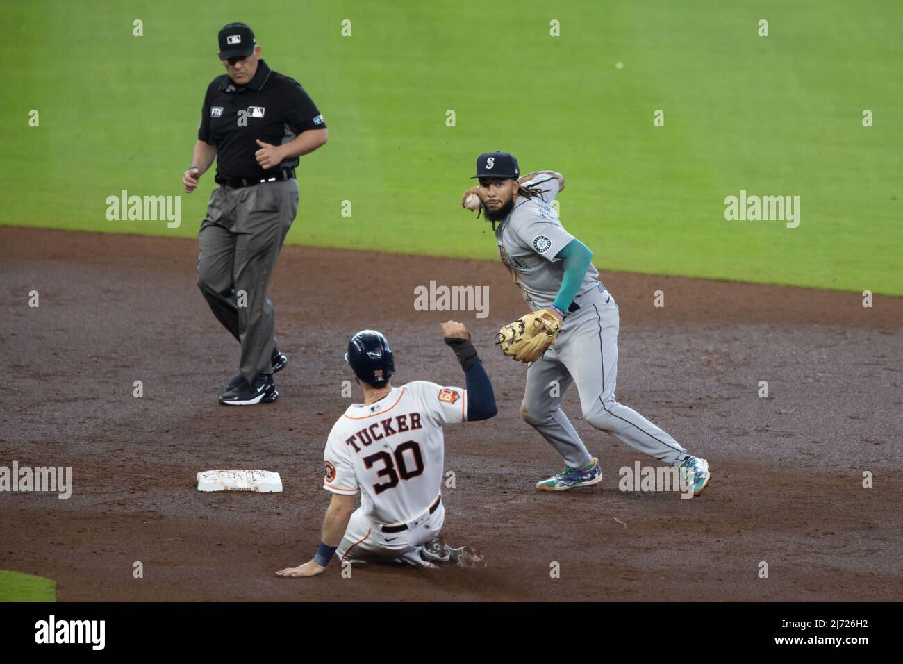 Seattle Mariners shortstop J.P. Crawford (3) turns a doulbe play as Houston Astros right fielder ...